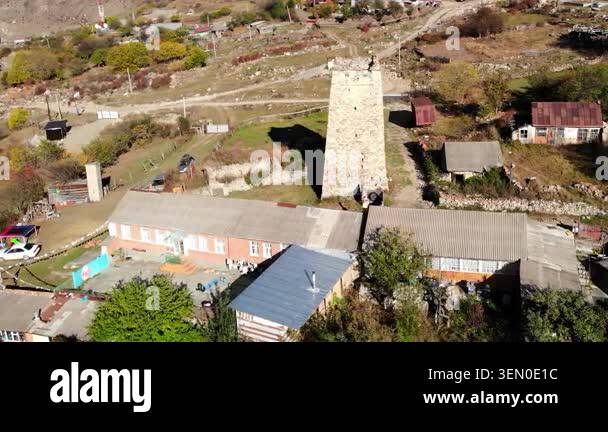 A bright aerial view of a rural settlement centered on a historic stone ...