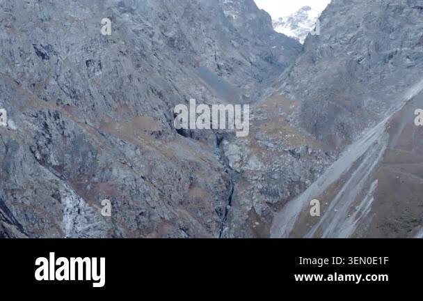 Wide view of a remote mountain gorge with steep rocky slopes, sparse ...