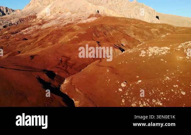 Wide scenic view of sunlit barren desert hills, rocky slopes, and ...