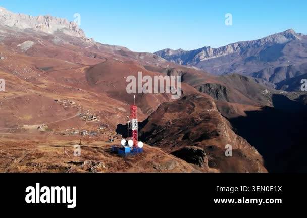 Wide aerial view of a remote telecommunications tower on a rocky ...