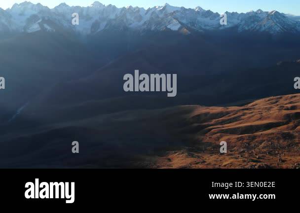 Wide aerial landscape of rugged barren hills and rocky ridges with snow ...