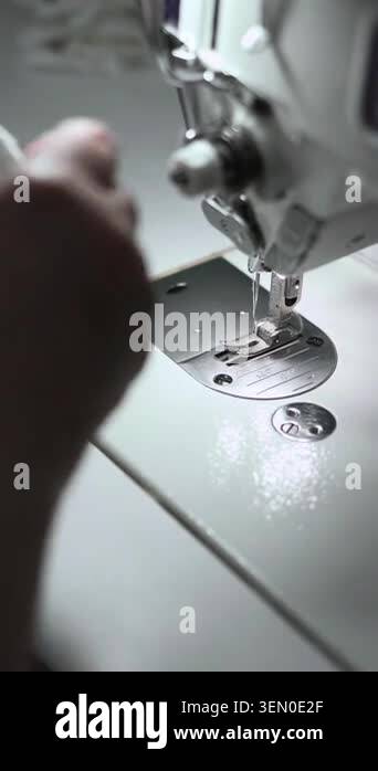 White Dressmaker Handfinishing Childs Garment On Sewing Machine ...