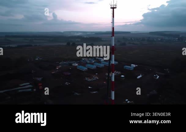 High aerial view of a red and white communications tower standing above ...