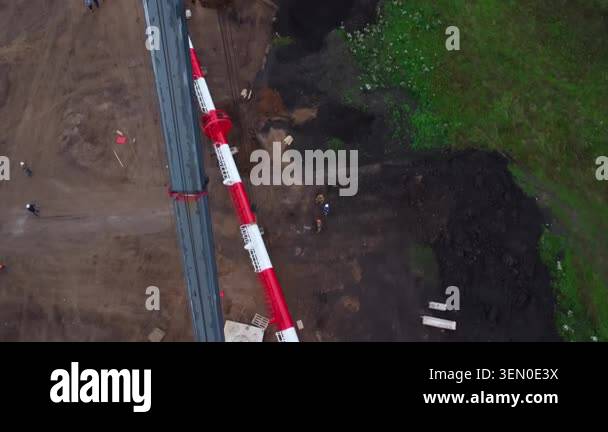 Top down view of a long red and white industrial structure crossing ...