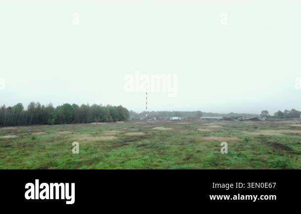 Empty grassy countryside stretches across a low horizon with a distant ...