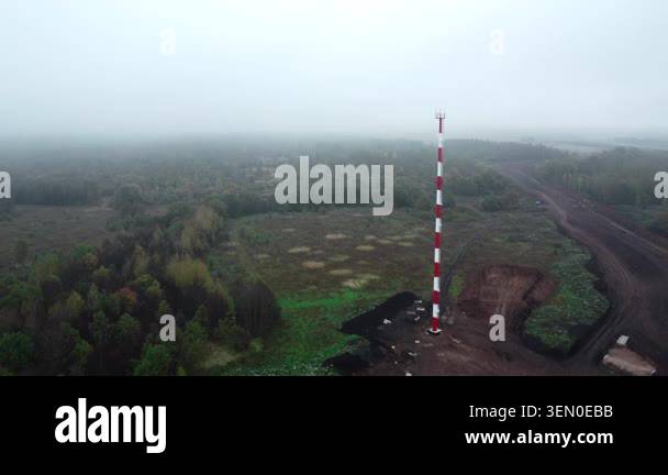 High aerial view of a misty rural landscape with dense trees, a dirt ...