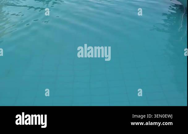 Real time close-up video of clear blue swimming pool water with gentle ...