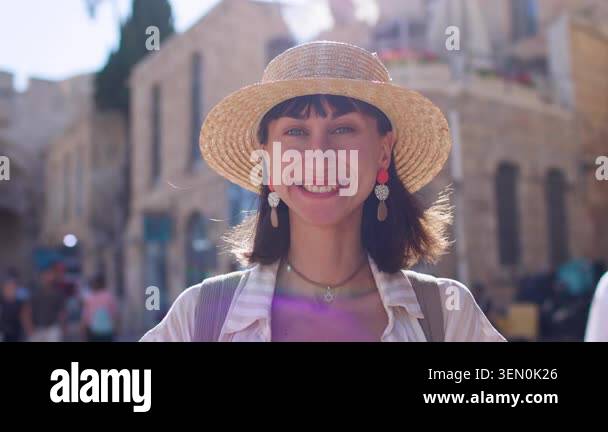 young woman strolling along a sunlit Jerusalem street during golden ...