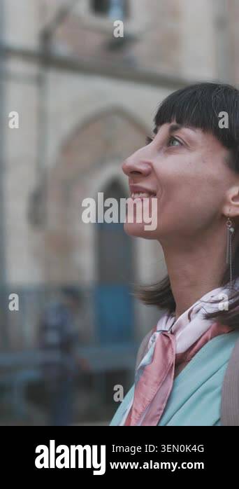 vertical shot. Close-up of a dark-haired woman holding a vintage camera ...