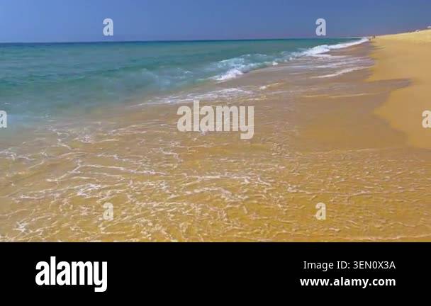 Ocean beach with beautiful blue water waves crashing onto the clean ...