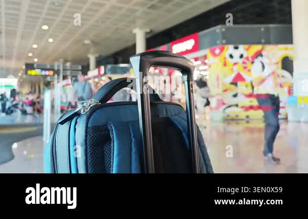 A time-lapse video of a blue travel bag standing still in an airport ...