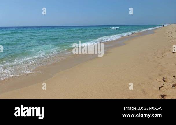 Ocean beach with beautiful blue water waves crashing onto the clean ...