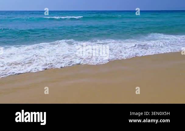 Ocean beach with beautiful blue water waves crashing onto the clean ...