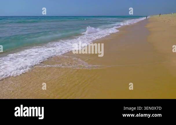 Ocean beach with beautiful blue water waves crashing onto the clean ...