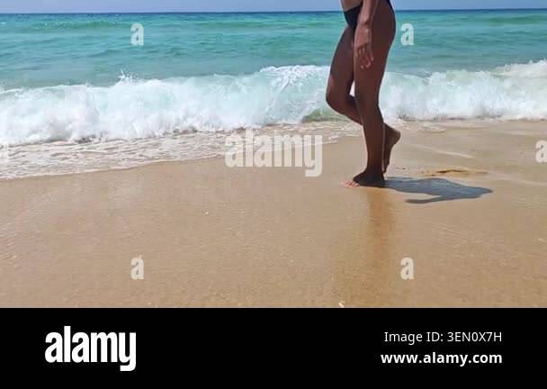A super slow-motion video of a teenage girl's feet walking along a ...