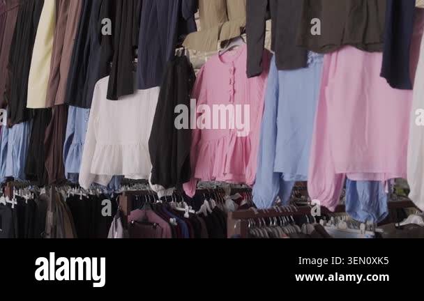 Pastel dresses hanging on boutique racks, soft fabrics and layered ...