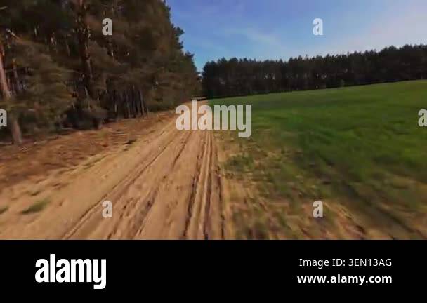 Dynamic FPV drone footage flying low over lush green cereal crops ...