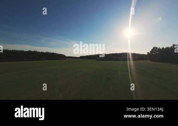 Dynamic FPV drone footage flying low over cultivated farmland with ...