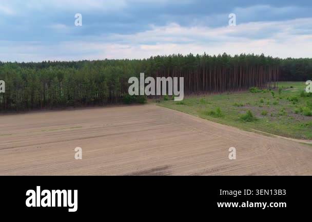 Drone footage showing contrast between plowed agricultural field and ...