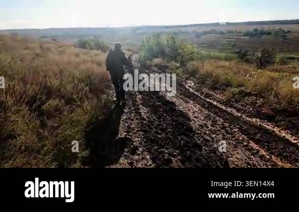 Volunteers in protective uniform jogging on dirty country road at ...