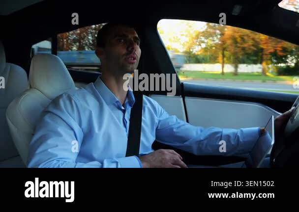Male businessman typing text on laptop during riding on electrical ...