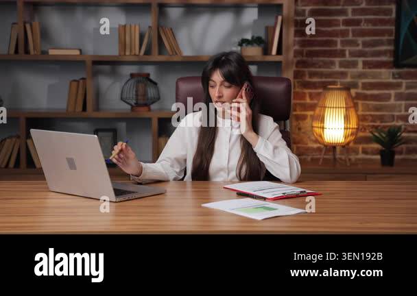 Caucasian business woman is talking on the phone while working at her ...
