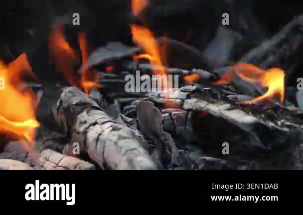 The fire is burning on a pile of blackened wood and charcoal Stock ...