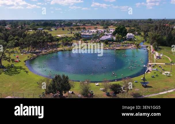 Warm mineral springs attraction with calm turquoise water, swimmers ...