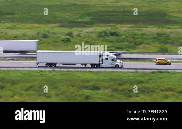 Aerial view of semi-truck driving on busy American interstate freeway ...