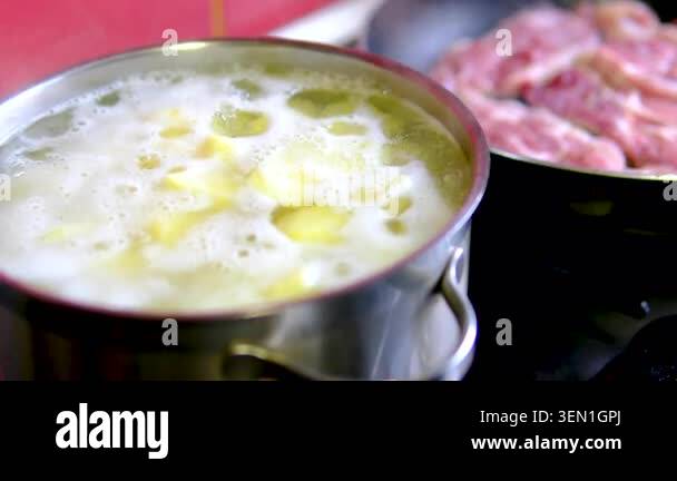 cover the pan with a glass lid Potatoes cook in bubbling water inside a ...