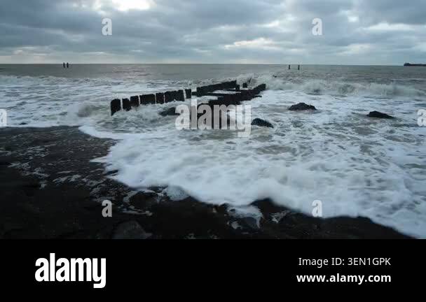 Foamy Sea Waves Crashing Against Weathered Wooden Groynes In a Stormy ...