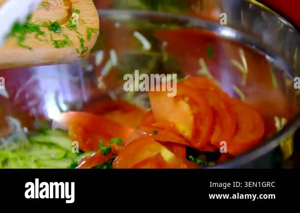 Chopped cabbage tomatoes and dill are carefully pushed from a wooden ...