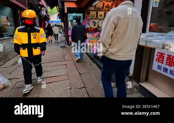 China, Shanghai - December 6, 2024: Food delivery guy walking in ...