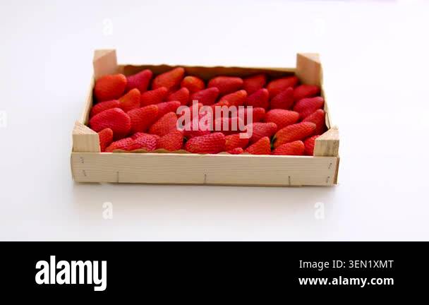 Big juicy strawberries arranged in rustic wooden box on clean white ...