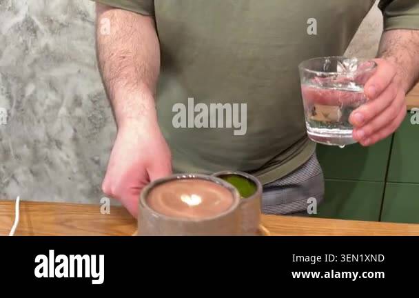 Male hands mixing cocoa powder with warm milk in gray green ceramic mug ...