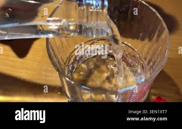 Clean water poured into glass from bottle before dining. Proper ...