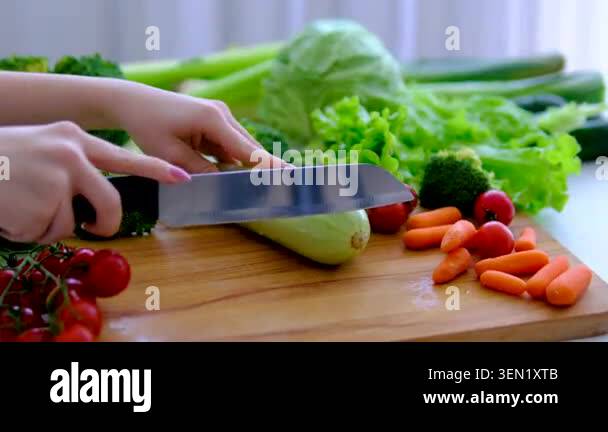 Young zucchini sliced into round pieces on wooden board beside broccoli ...