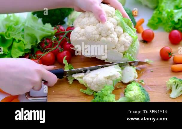 Chopped broccoli and other vegetables on wooden cutting board ...