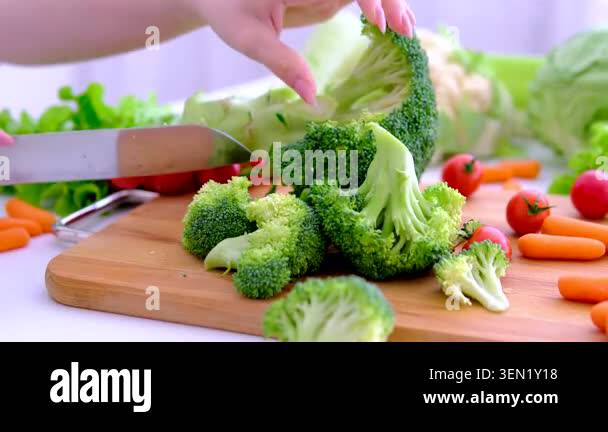 Preparing broccoli for cooking. Cutting broccoli cabbage on a cutting ...