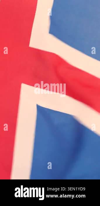 Close-up of Iceland national flag waving. Blue with a white cross and a ...