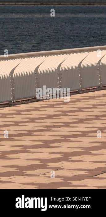 Seaside promenade with waterfront railing and paved walkway along ocean ...