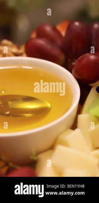 Cheese platter with sliced cheese and honey served as gourmet appetizer ...