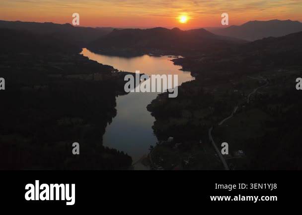 Aerial drone view of Colibita lake partially visible between darkened ...