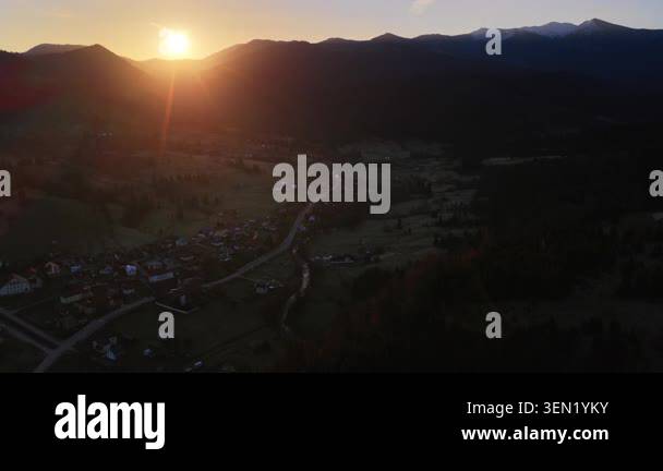 Aerial drone view down a valley with a road and scattered houses ...