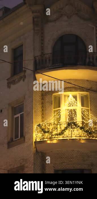 Christmas tree with lights on balcony in cozy European winter evening ...