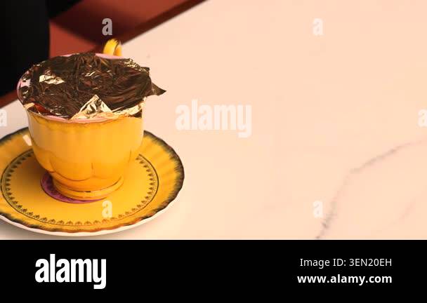 Luxury cappuccino with edible gold leaf served in elegant yellow coffee ...