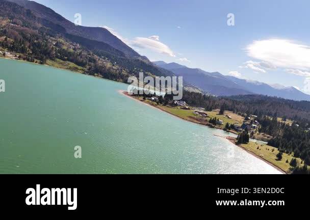 Aerial drone view of Colibita Lake with turquoise waters surrounded by ...