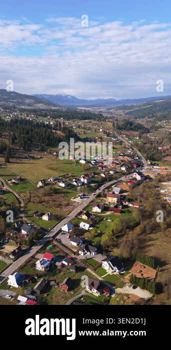 Aerial drone view of a winding river cutting through a rural settlement ...