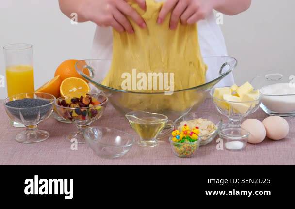 A girl carefully kneads soft golden dough while eggs, poppy seeds ...
