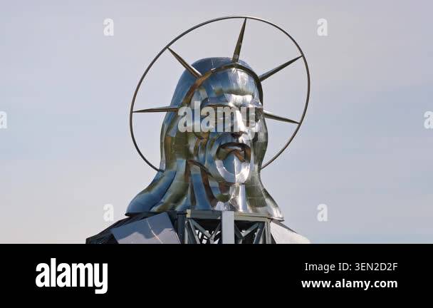 Aerial drone view of a steel Christ head with a radiating halo against ...